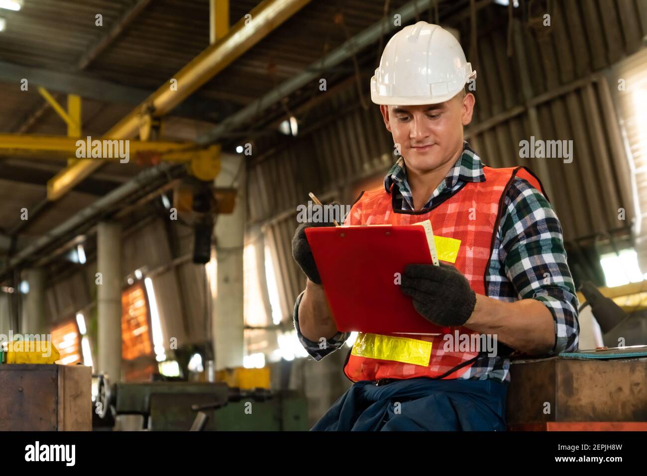 Manufacturing worker working with clipboard to do job procedure ...