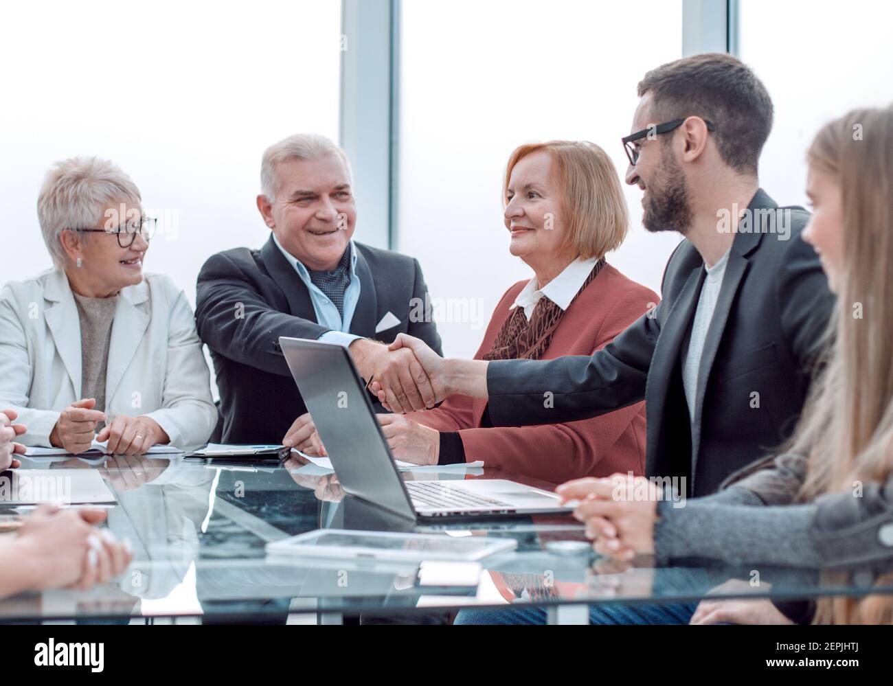 Businesswoman leads meeting around table Stock Photo - Alamy