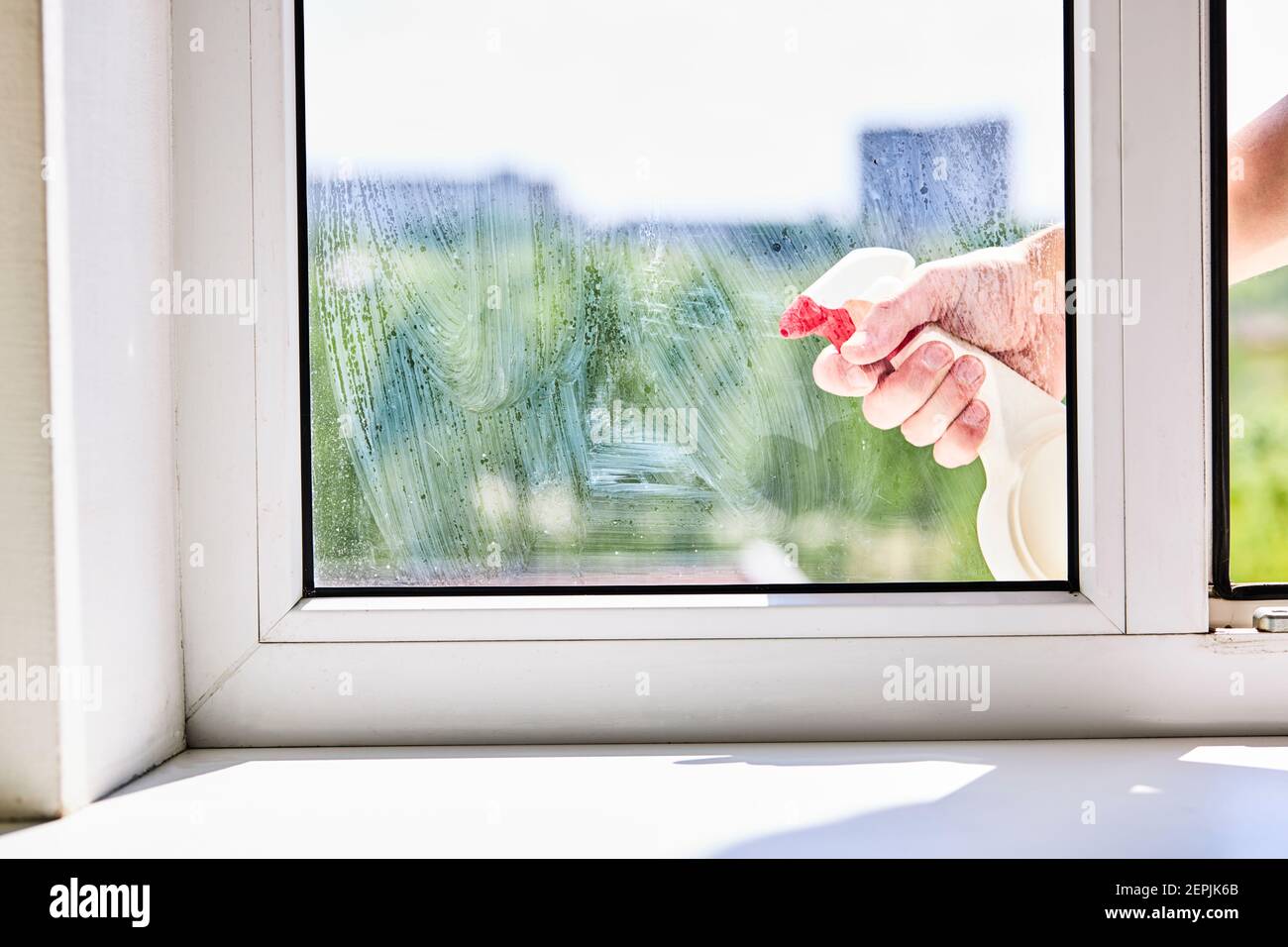 cleaning or washing dirty domestic window with a chemical spray ...