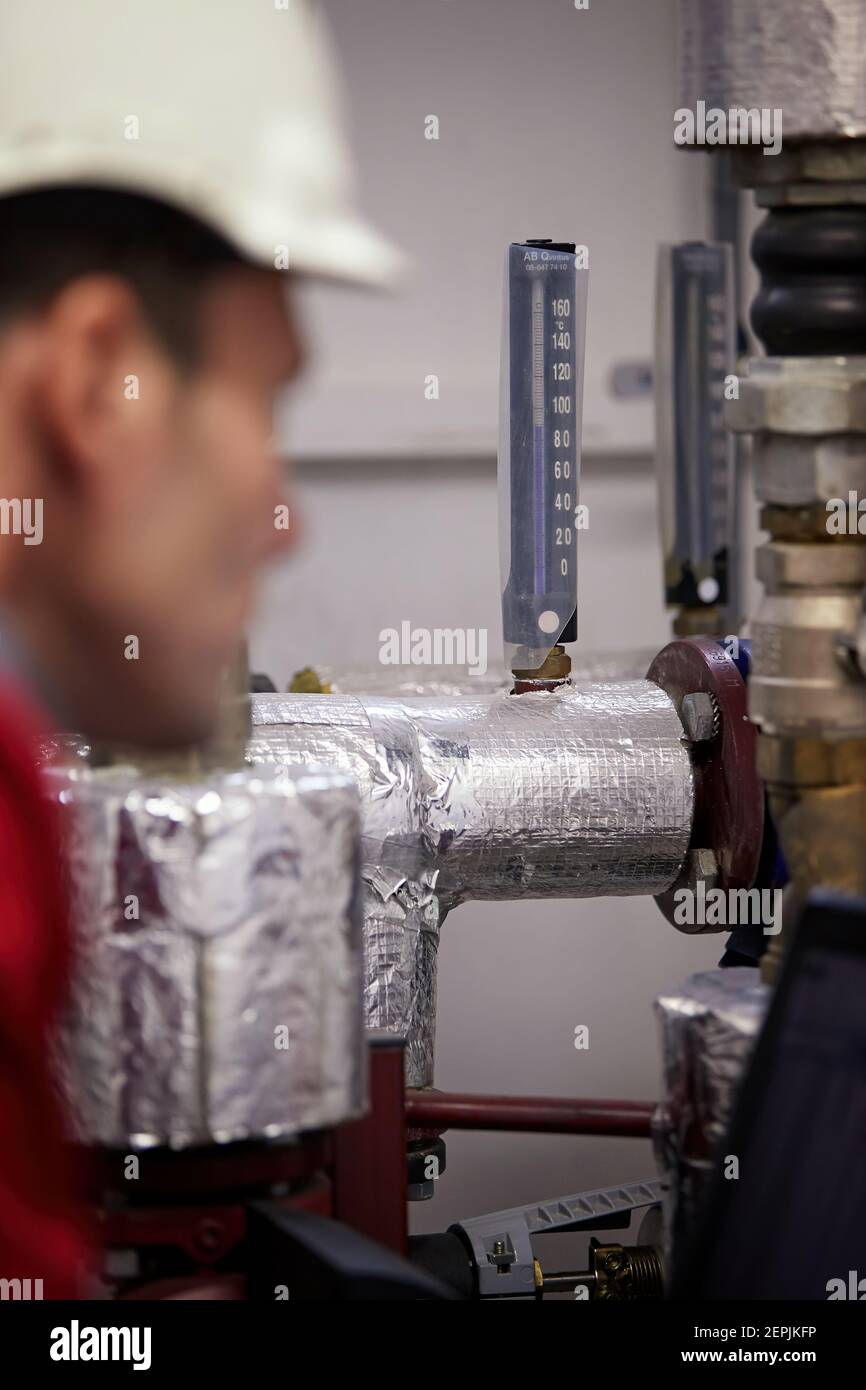 Energy industry. A technician dressed in red overalls and a white ...
