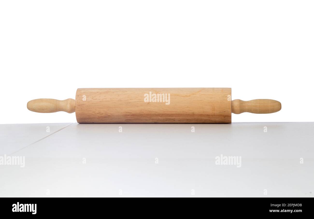 Horizontal shot of of an old wooden rolling pin on a table’s edge with ...