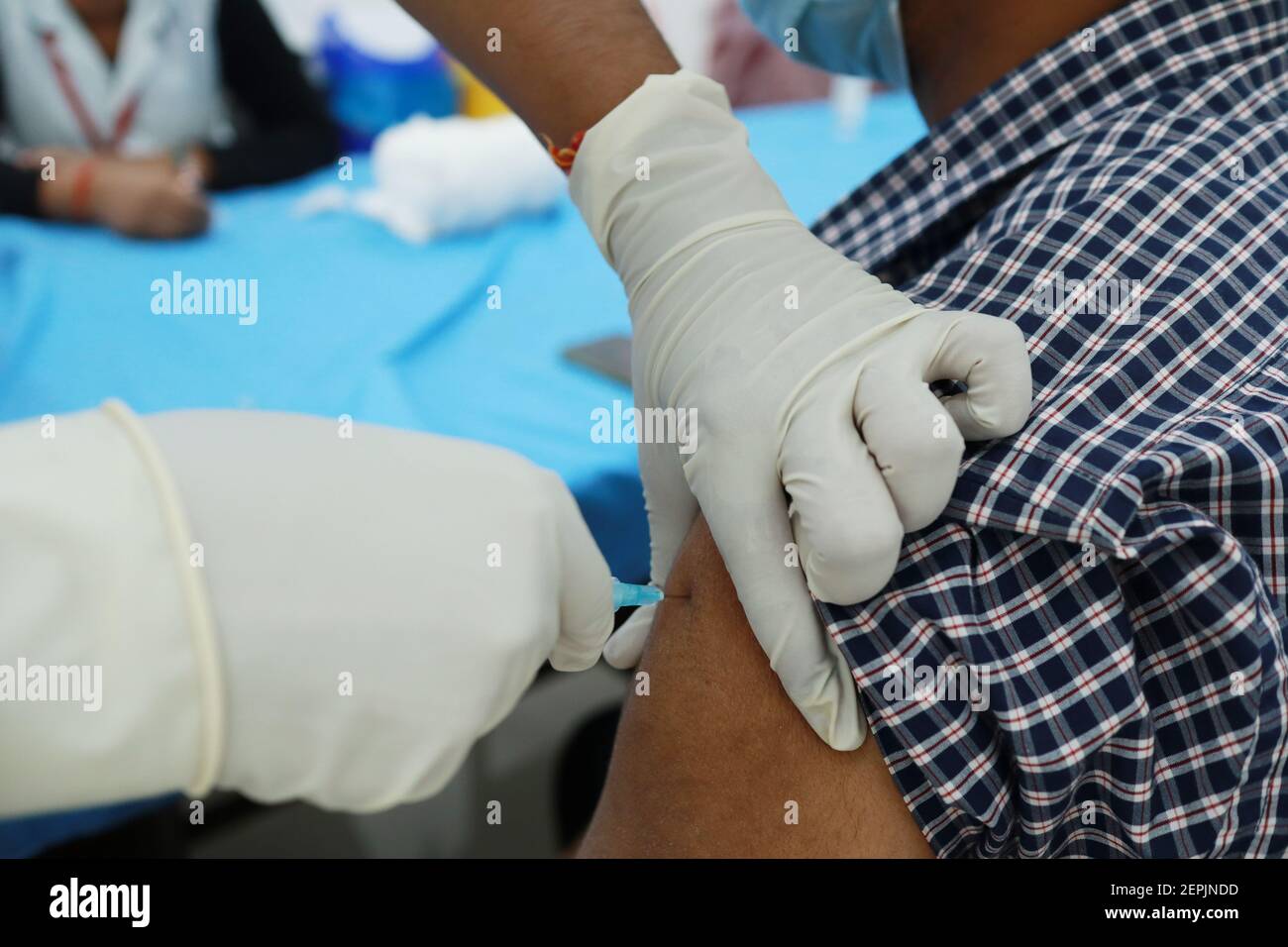 gloved hand giving injection in a shoulder.corona virus vaccination ...