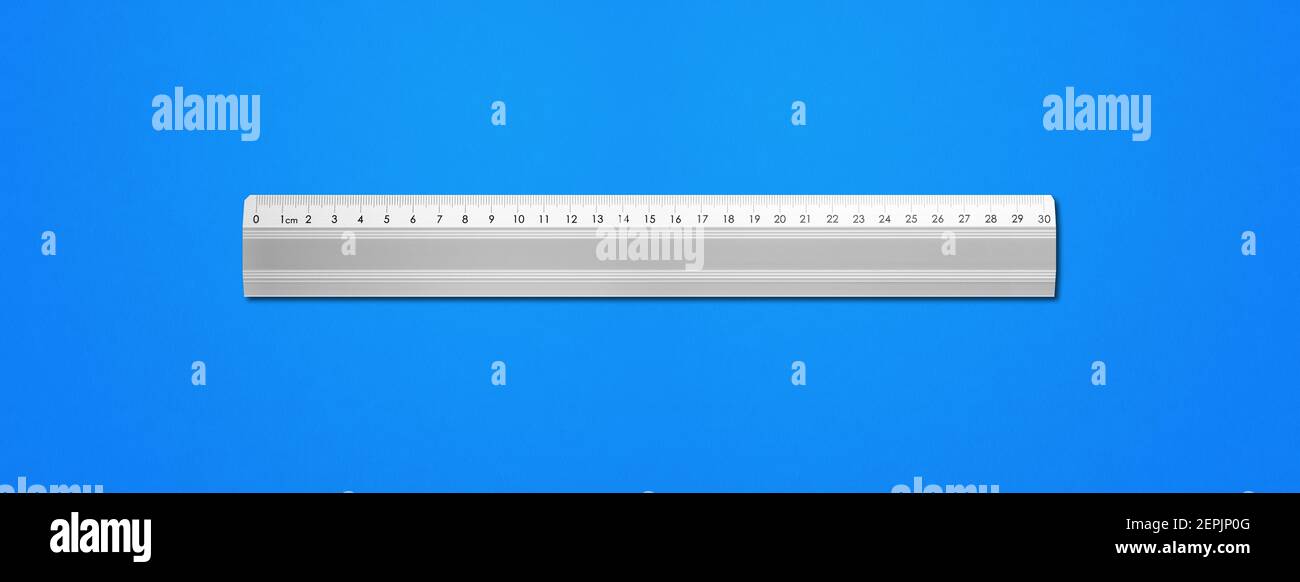 Steel metallic ruler isolated on blue background Stock Photo - Alamy
