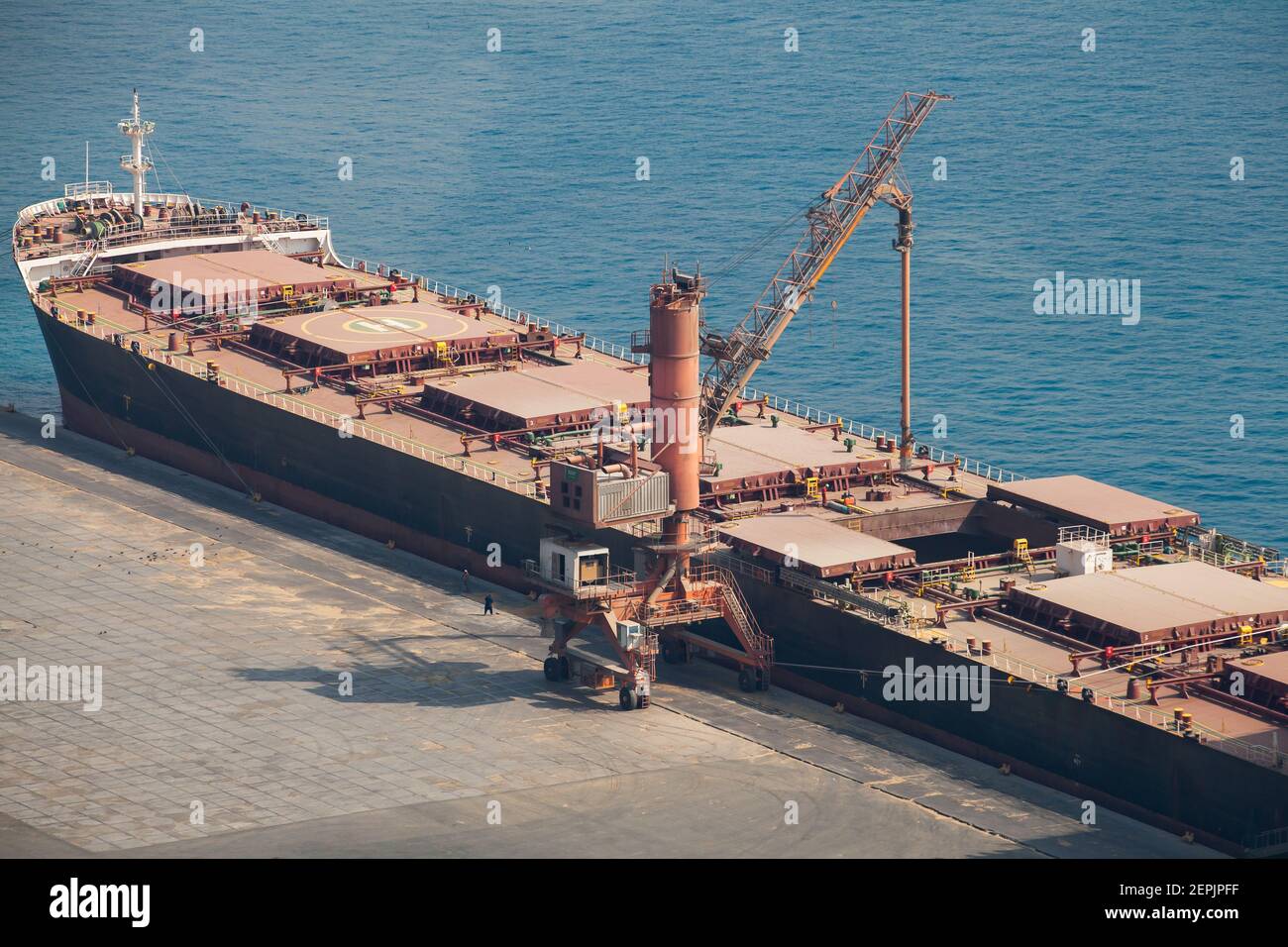Unloading of a bulk carrier ship in a port on a sunny day. Red sea coast, Saudi Arabia Stock ...