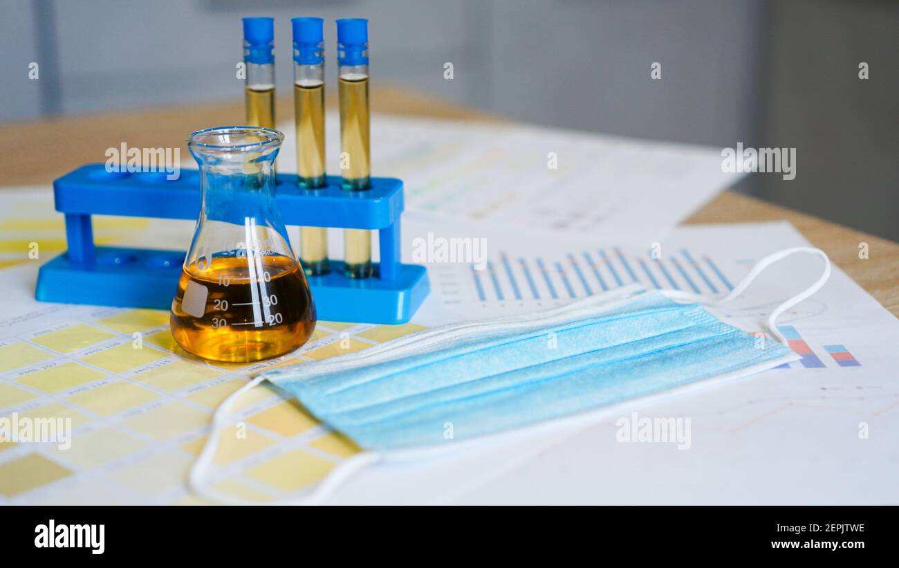 Flask,test tubes and mask with urine on medical color schemes. The ...