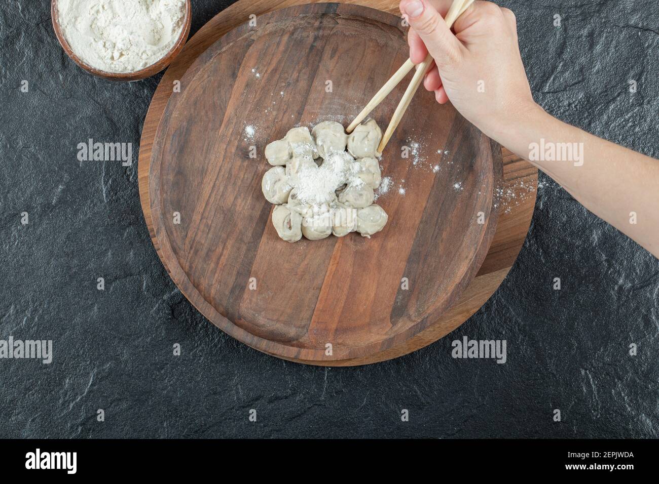 Hand holding a chopstick with a dumpling Stock Photo - Alamy