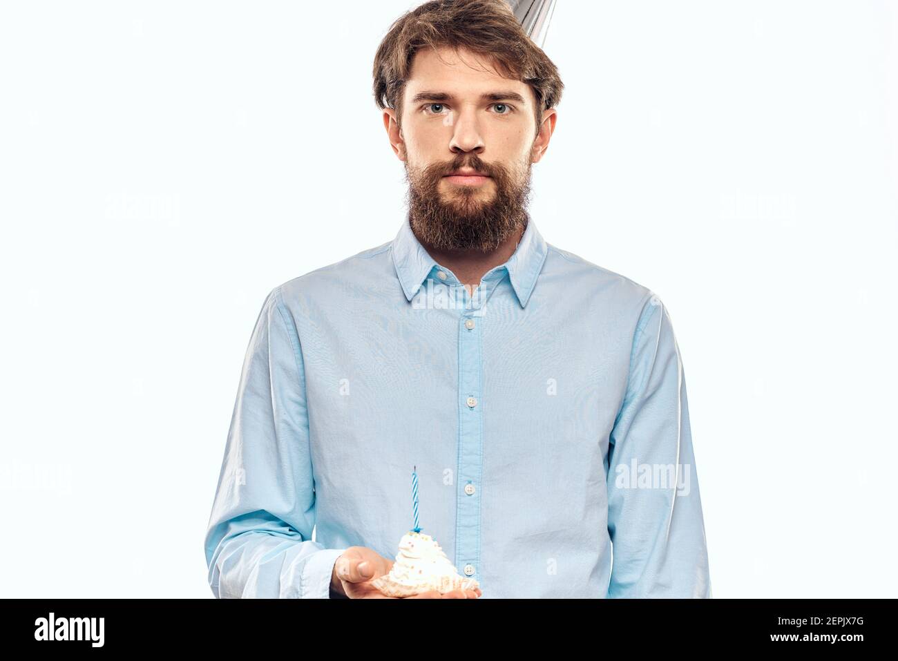 A man with a cake plate and in a blue shirt on a light background ...