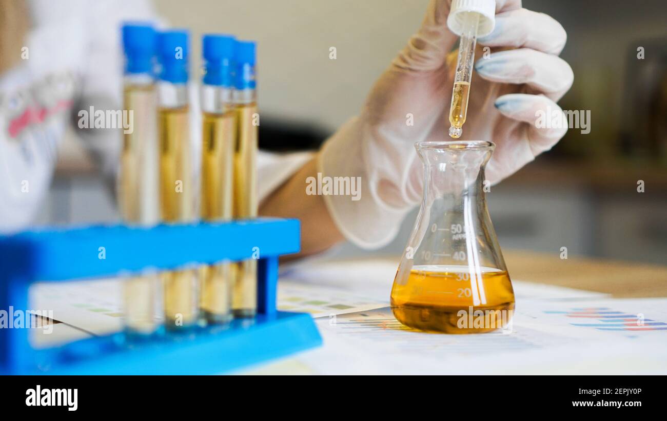 Woman making urine test with ph material in laboratory. Female hands in ...