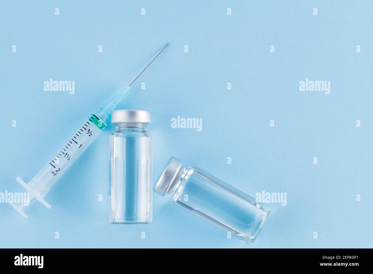 Vaccine and syringe injection. Vaccines and syringe on a blue ...