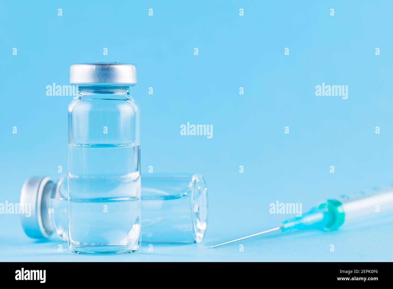 Vaccine and syringe injection. Vaccines and syringe on a blue ...