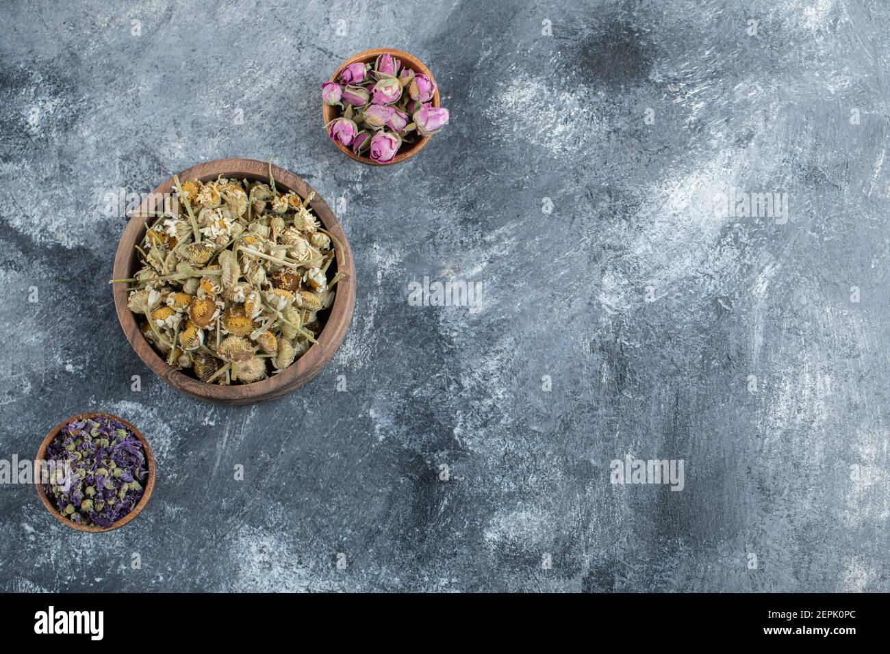 Three bowls of dried flower tea on marble background Stock Photo - Alamy