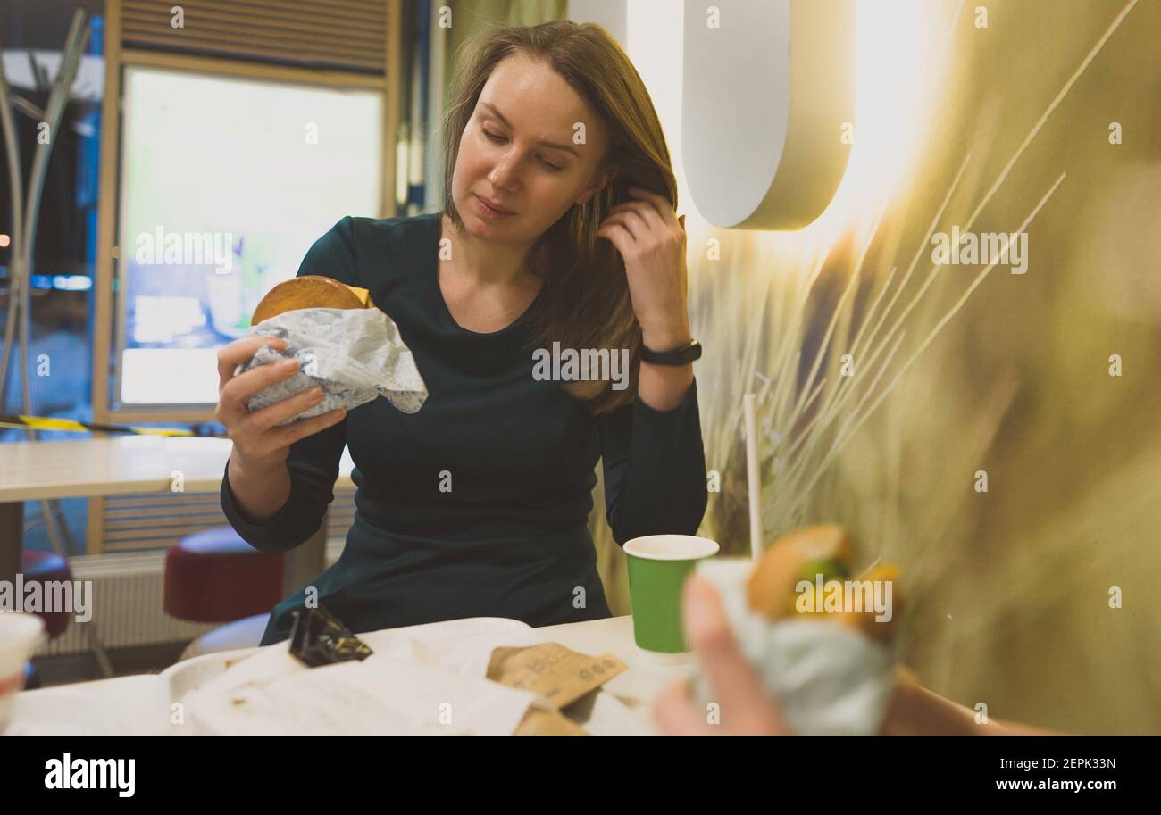 Woman with hamburger in a fast food restaurant Stock Photo - Alamy
