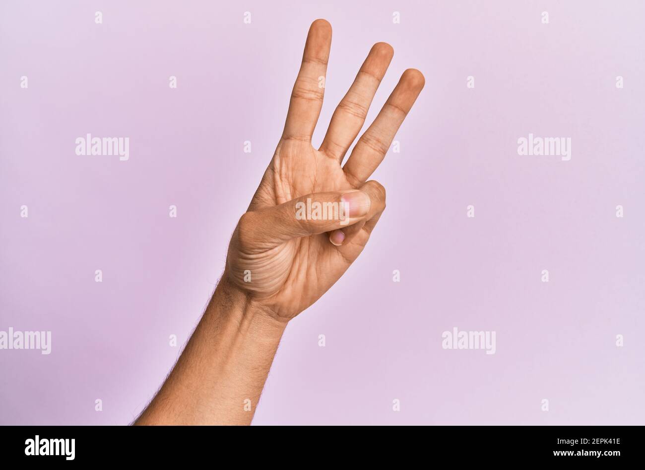 Arm and hand of caucasian young man over pink isolated background ...