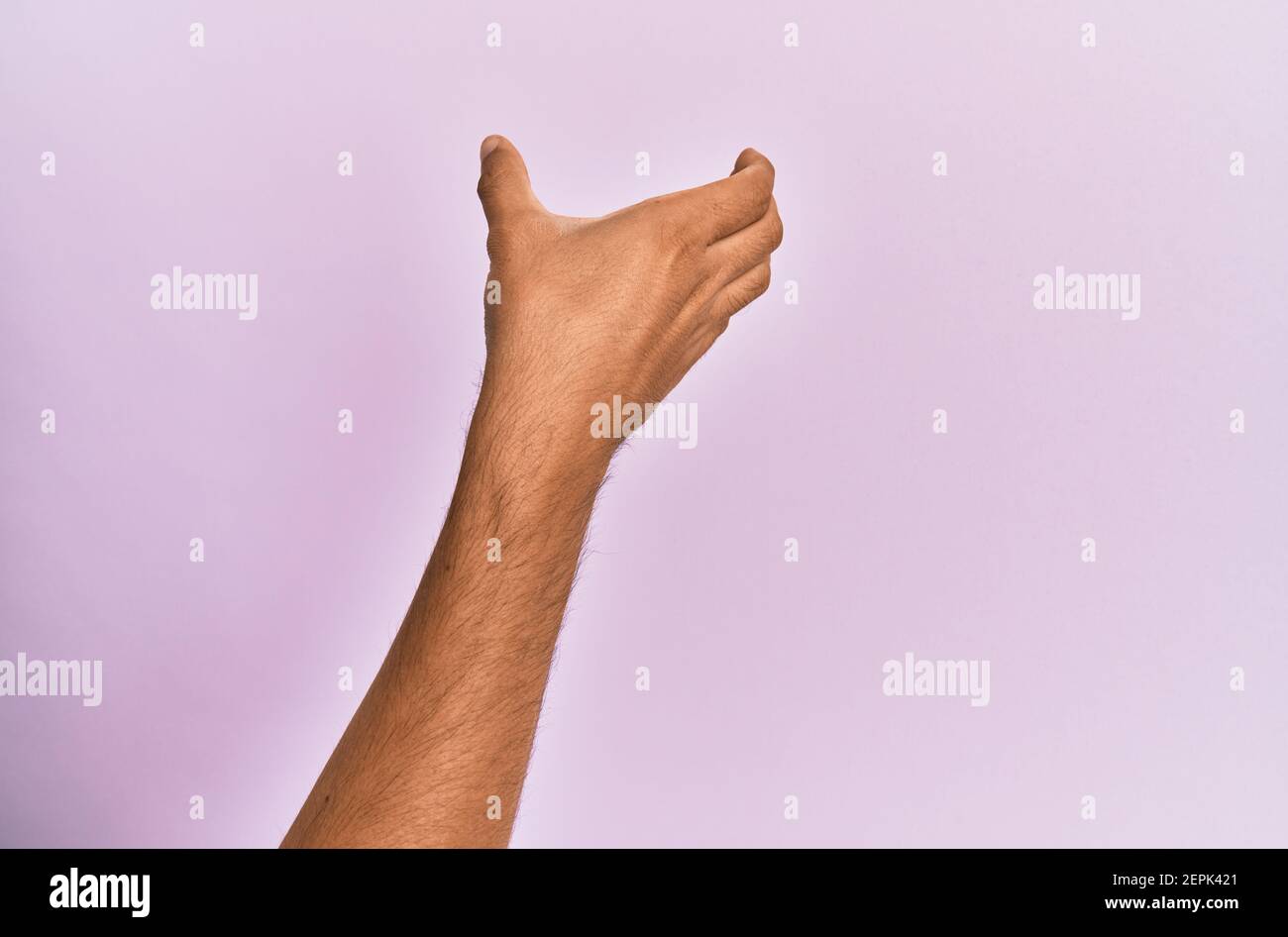 Arm and hand of caucasian young man over pink isolated background ...