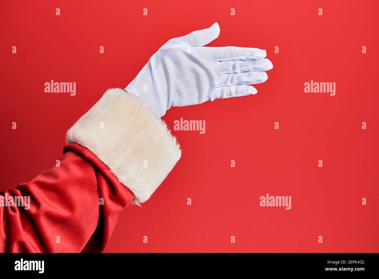 Hand of a man wearing santa claus costume and gloves over red ...