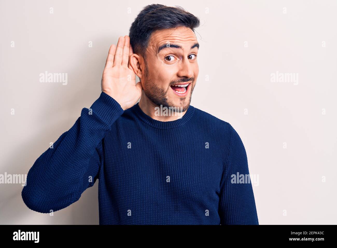 Young handsome man with beard wearing casual sweater standing over ...