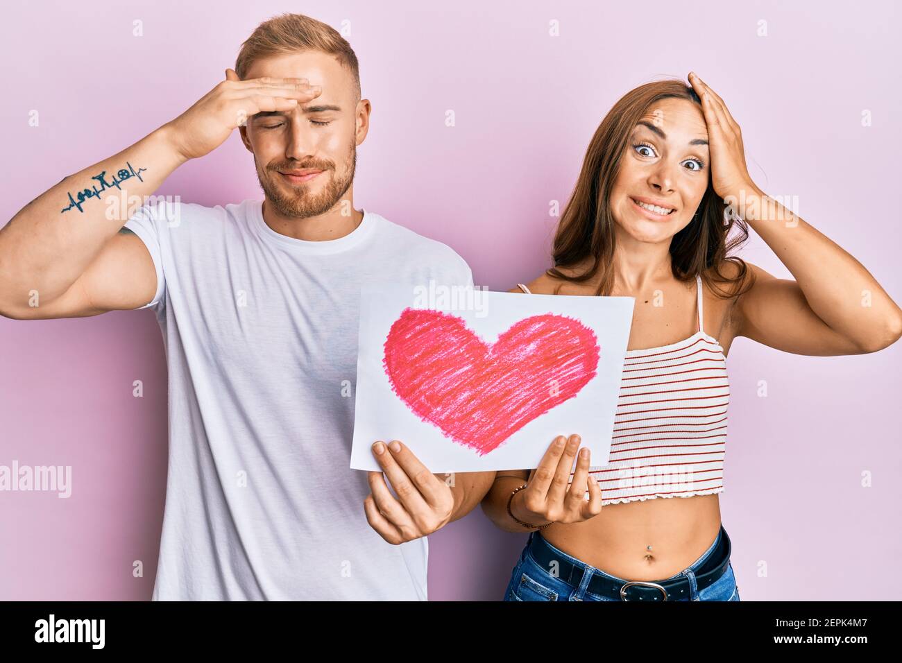 Young couple of girlfriend and boyfriend holding heart draw stressed ...