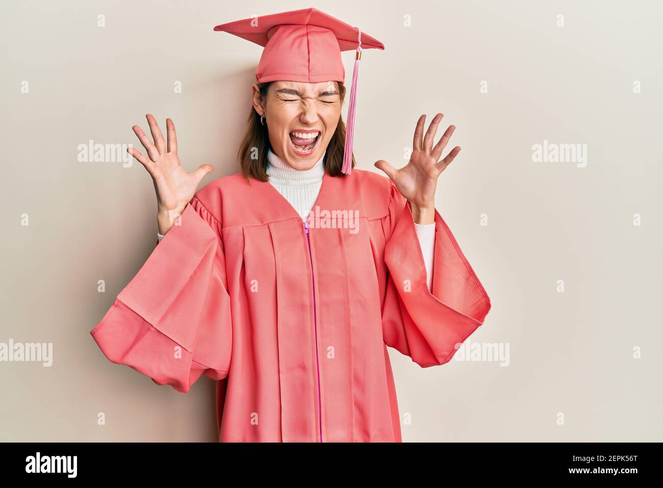 Young caucasian woman wearing graduation cap and ceremony robe ...