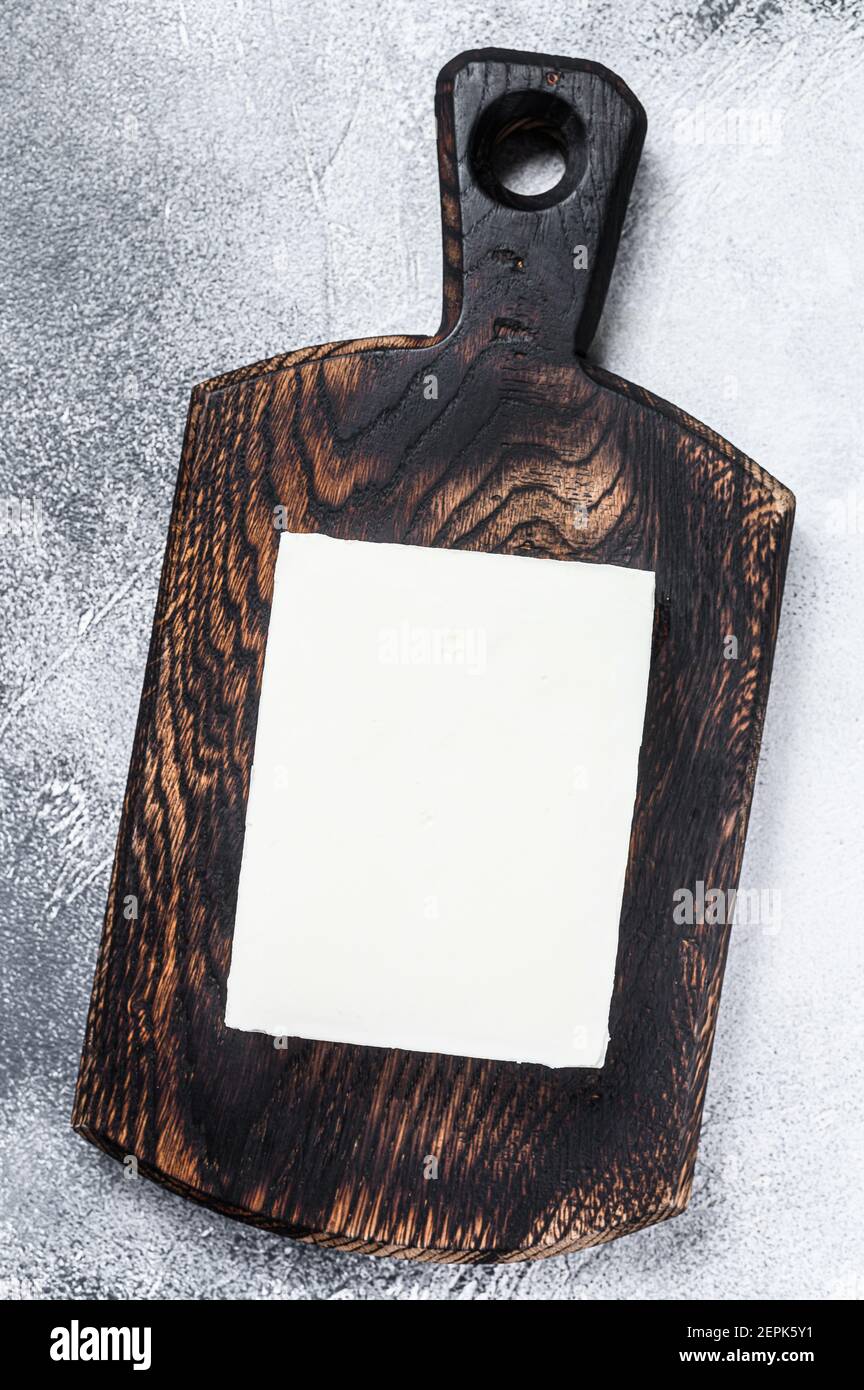 Pieces Of Fresh Paneer Cheese on a cutting board. White background. Top ...