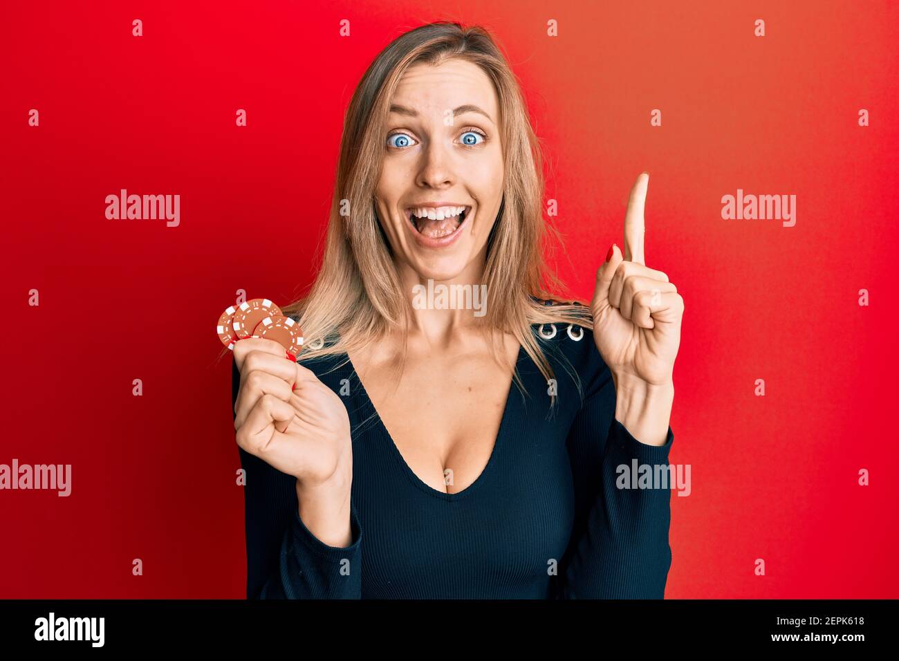 Beautiful caucasian woman playing poker holding casino chips smiling ...