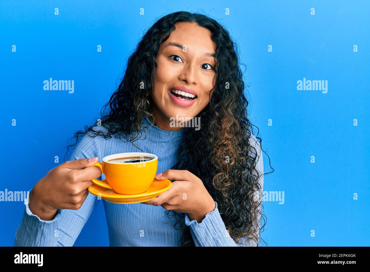 Young latin woman holding coffee celebrating crazy and amazed for ...