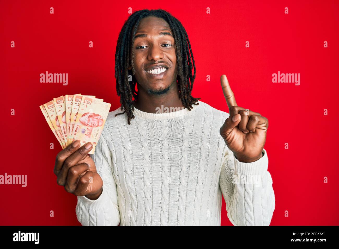 African american man with braids holding 100 mexican pesos banknotes ...