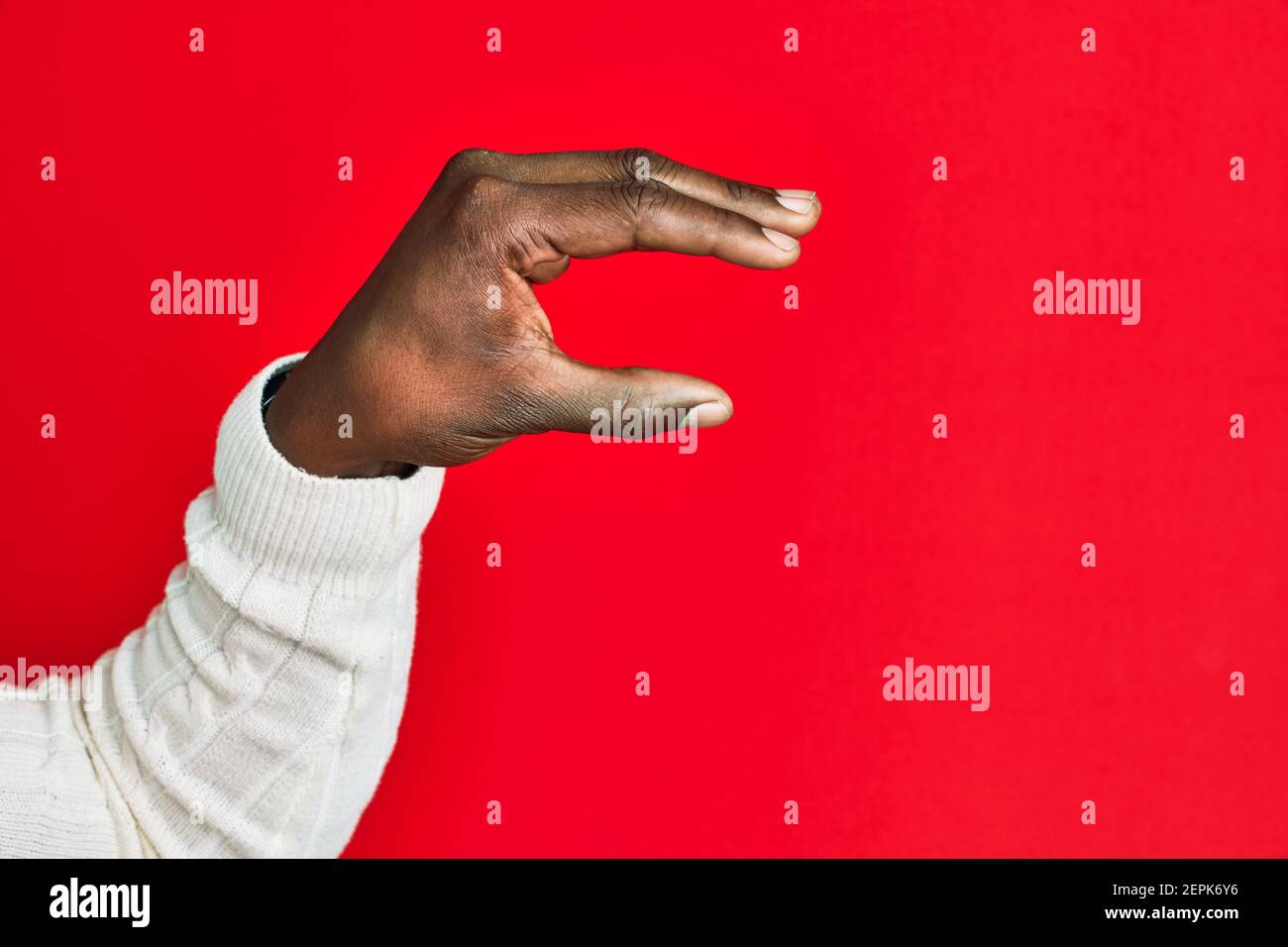 Arm and hand of african american black young man over red isolated ...