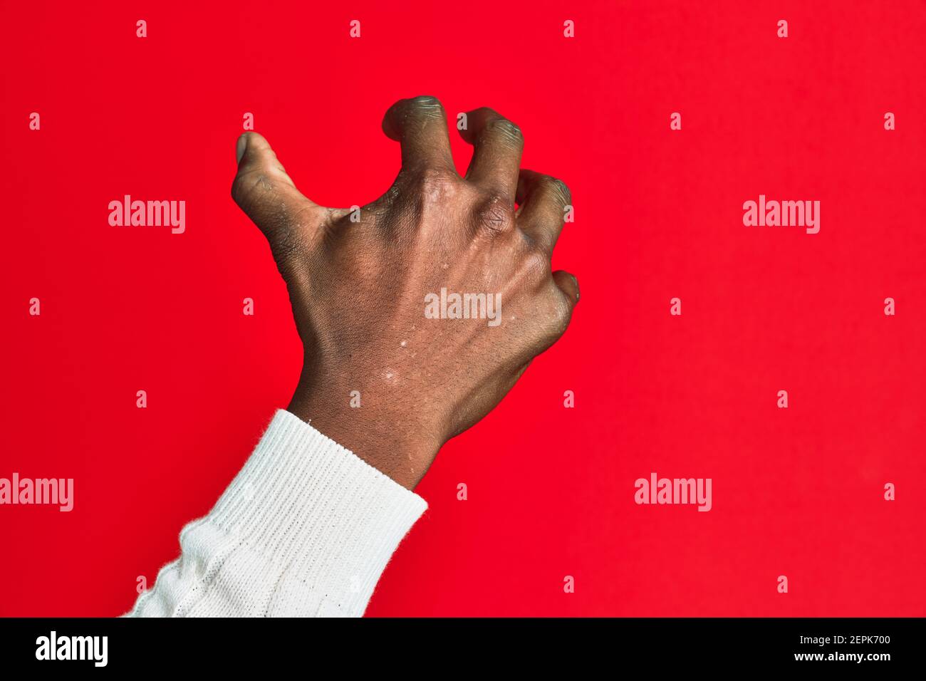 Arm and hand of african american black young man over red isolated ...