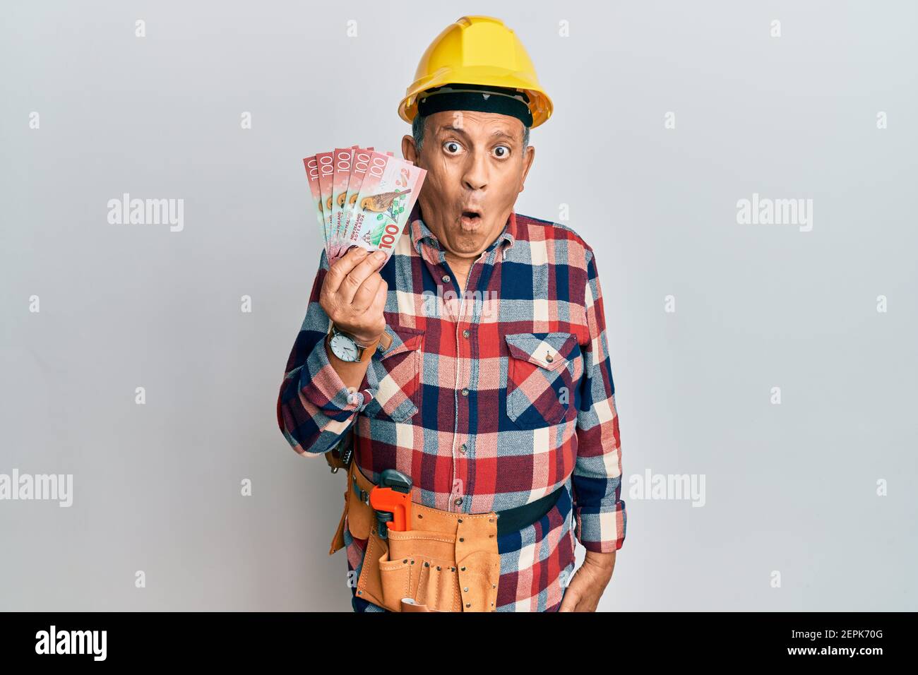 Senior hispanic man wearing handyman uniform holding new zealand ...