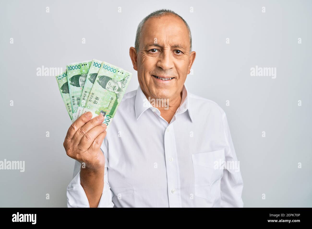 Handsome senior man holding 10000 south korean won banknotes looking ...