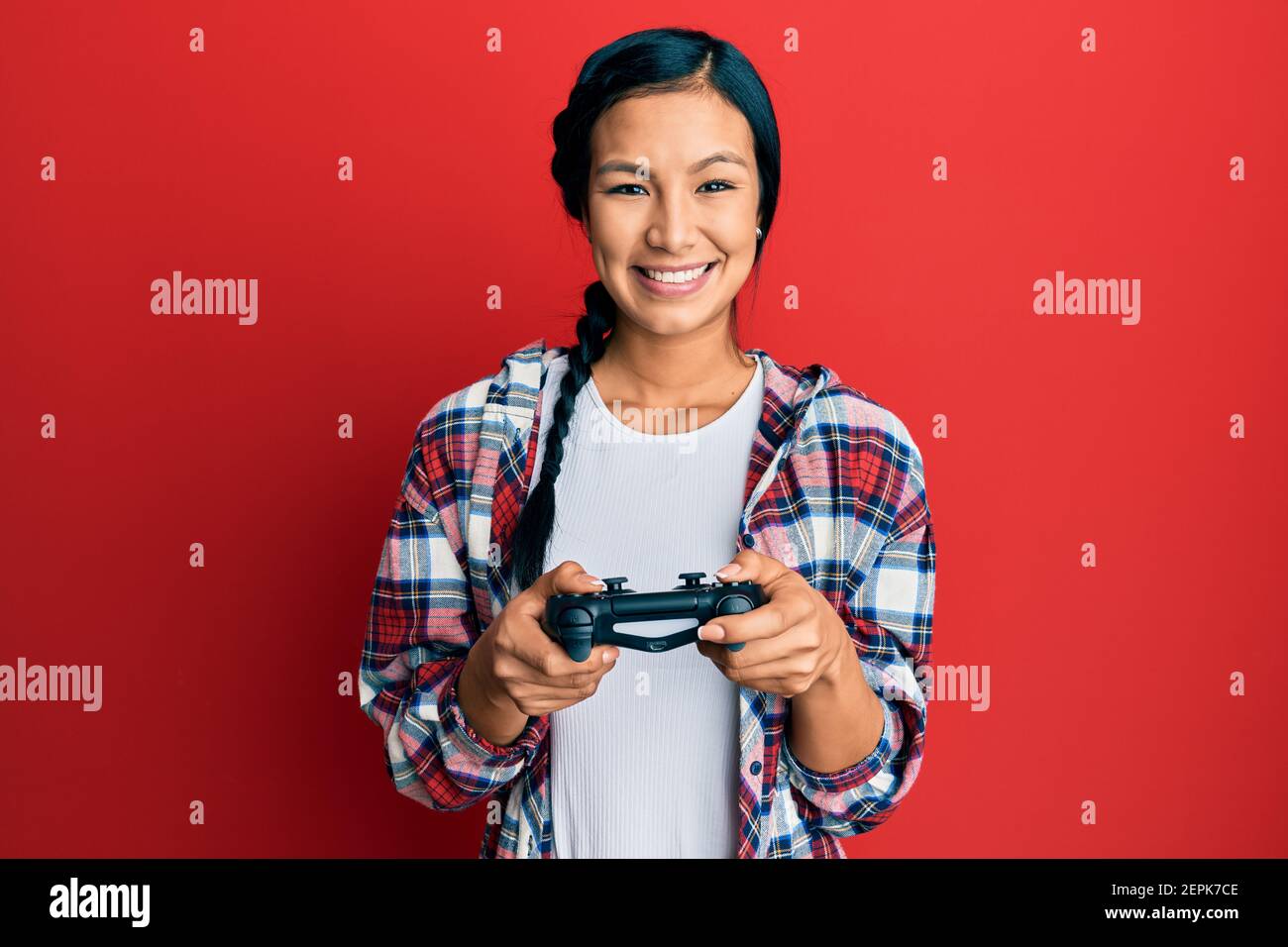 Beautiful hispanic woman playing video game holding controller smiling ...