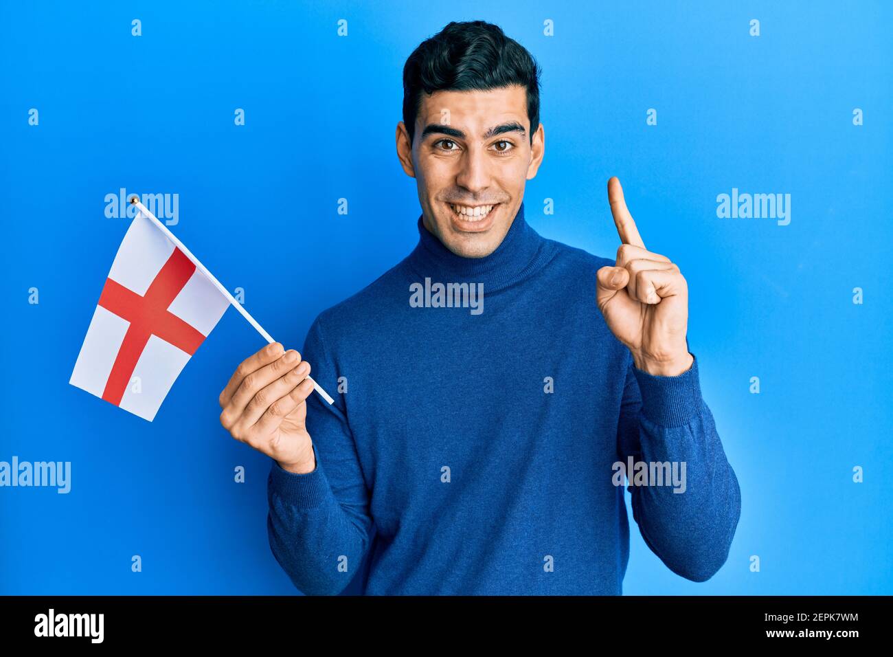 Handsome hispanic man holding england flag smiling with an idea or ...