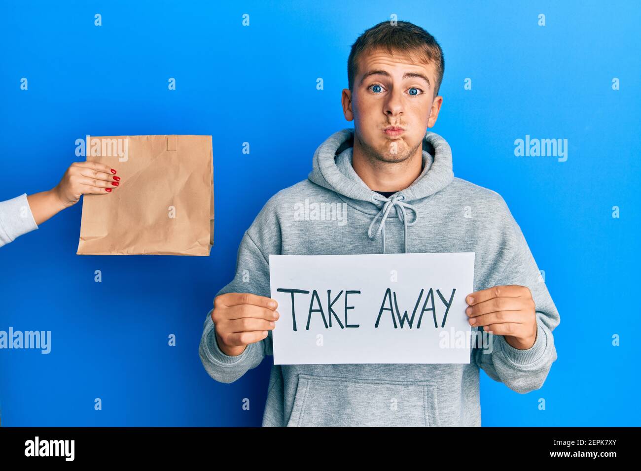Young caucasian man holding take away banner reciving delivery paper ...
