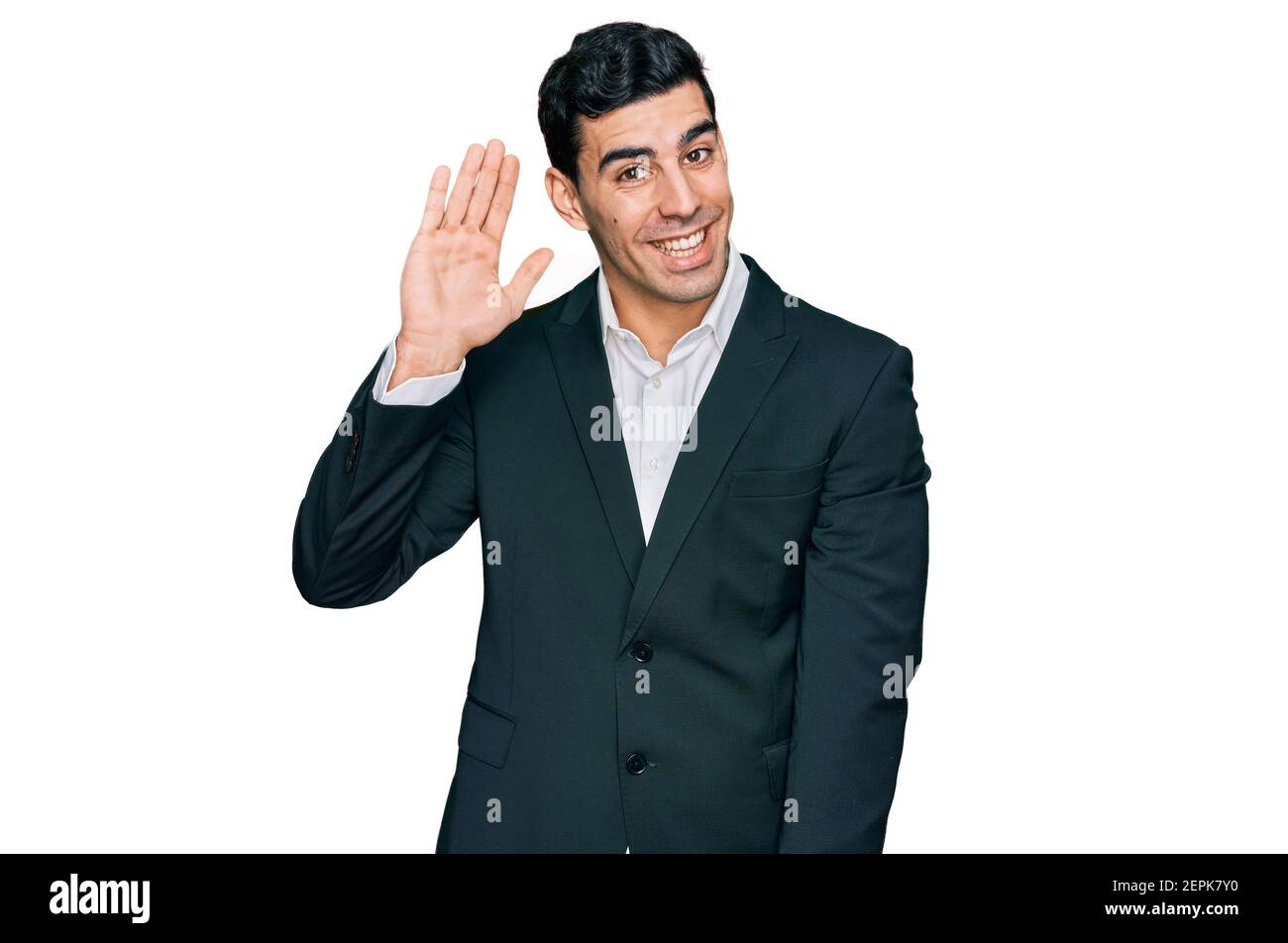 Handsome hispanic man wearing business clothes waiving saying hello ...