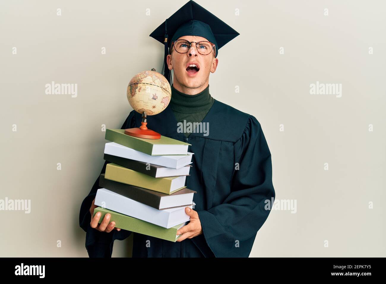 Young caucasian man graduated on geography angry and mad screaming ...