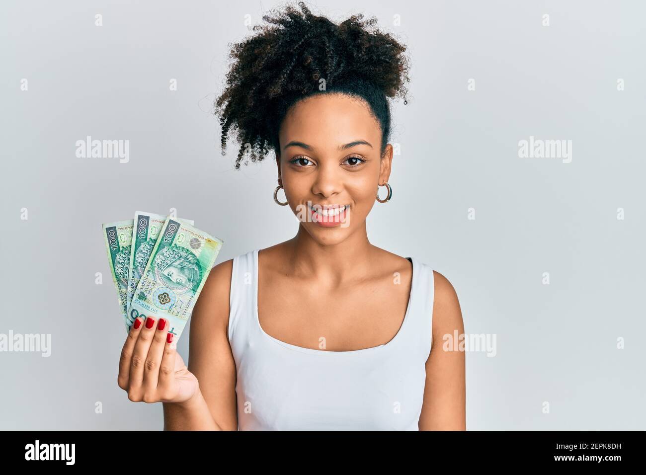 Young African American Girl Holding 100 Polish Zloty Banknotes Looking