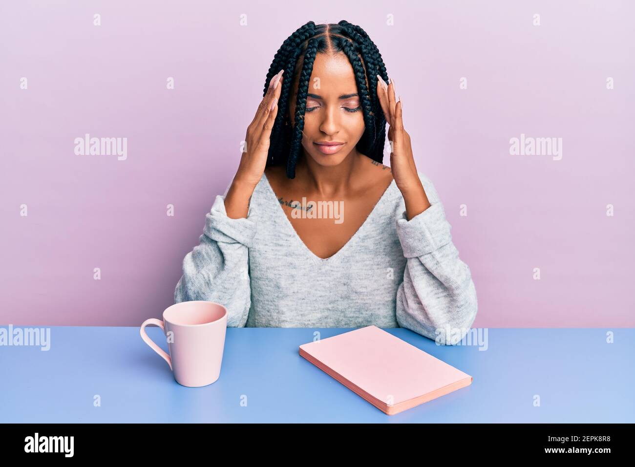 Beautiful hispanic woman reading a book and drinking a coffee suffering ...