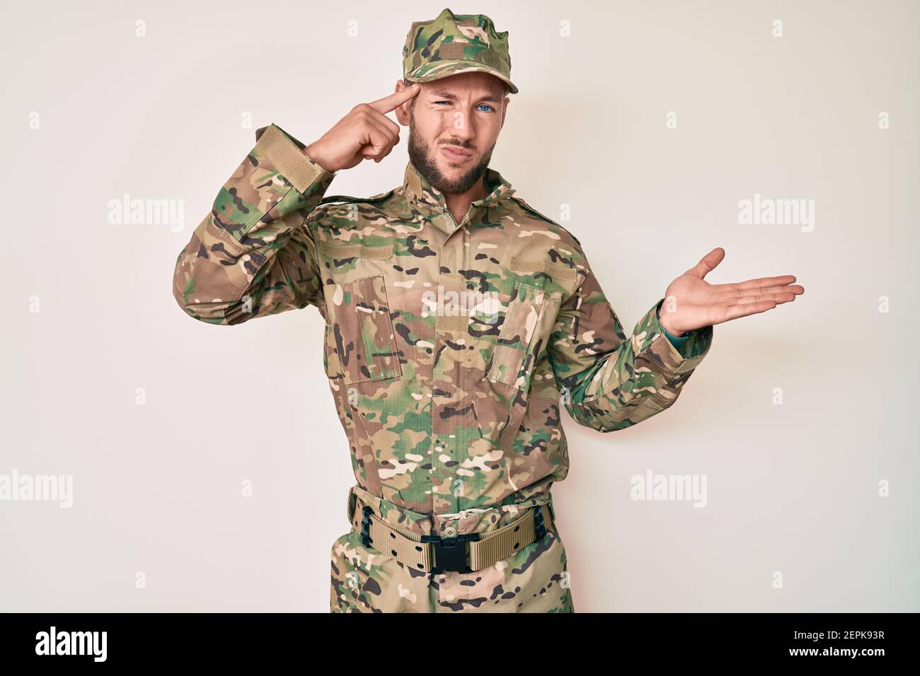 Young caucasian man wearing camouflage army uniform confused and ...