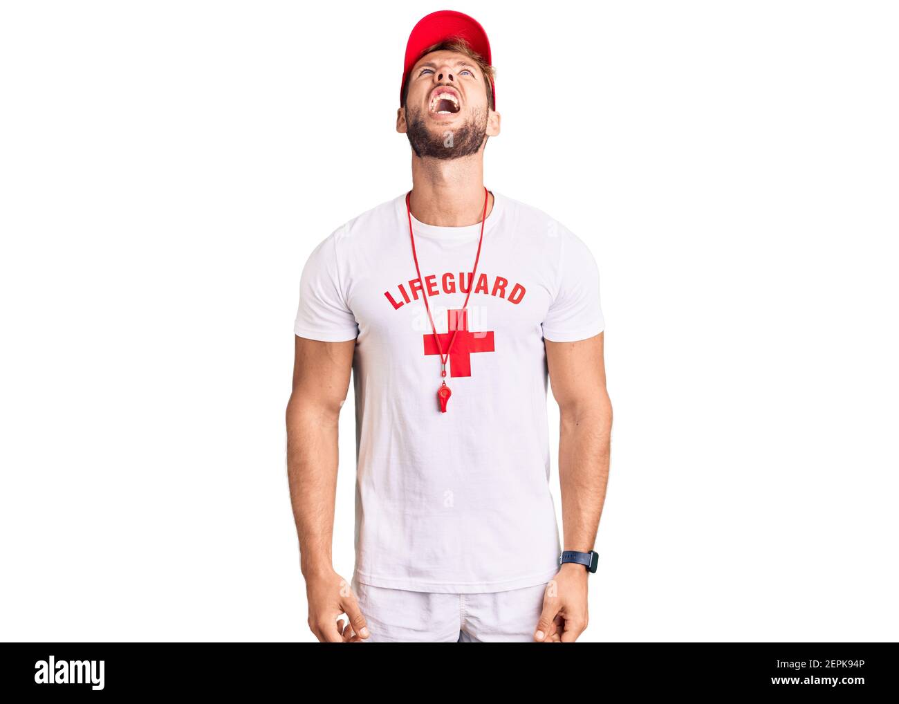 Young caucasian man wearing lifeguard t shirt holding whistle angry and ...