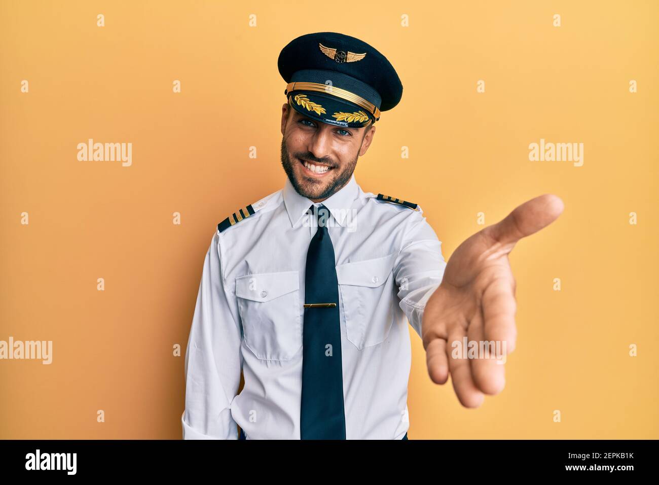 Handsome hispanic man wearing airplane pilot uniform smiling cheerful ...