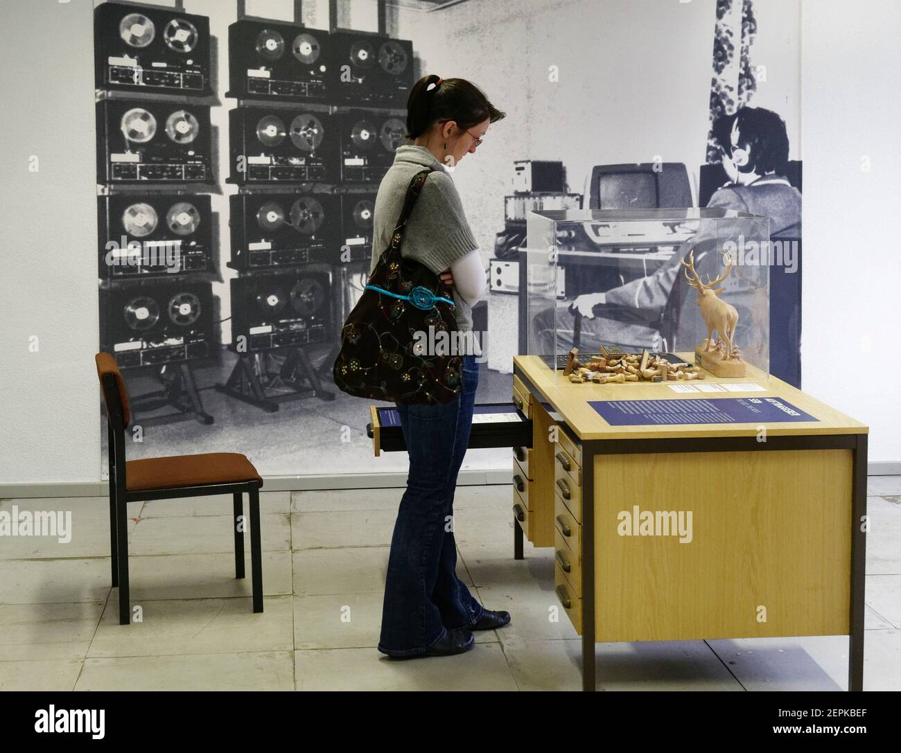 A visitor looking at a pile of rubber stamps in the Stasi Museum ...