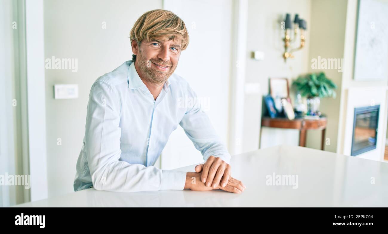 Young irish man smiling happy sitting on the table at home Stock Photo ...