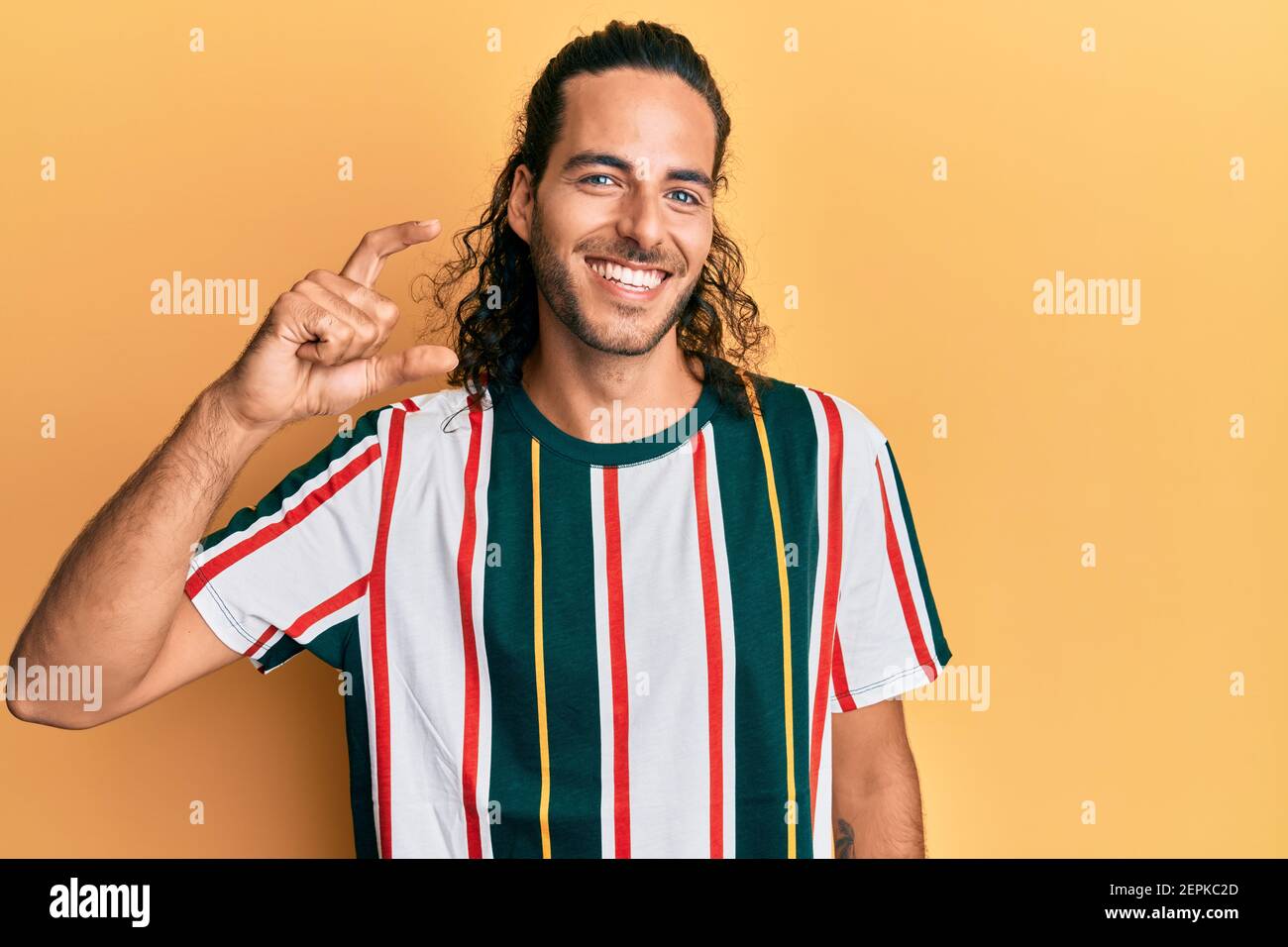 Young handsome man with long hair wearing casual clothes smiling and ...