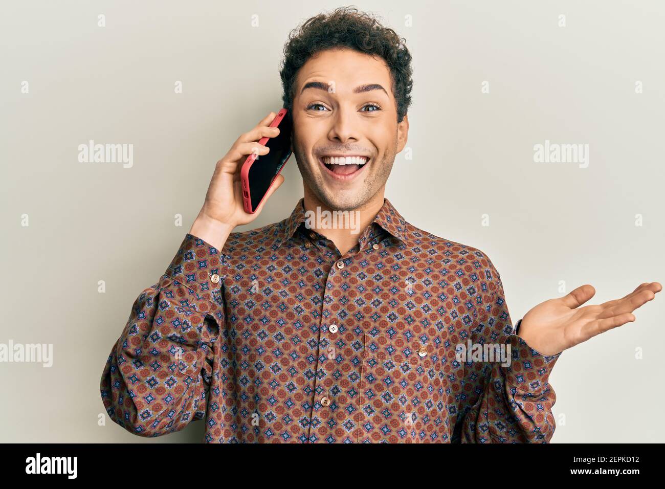 Young handsome man having conversation talking on the smartphone ...