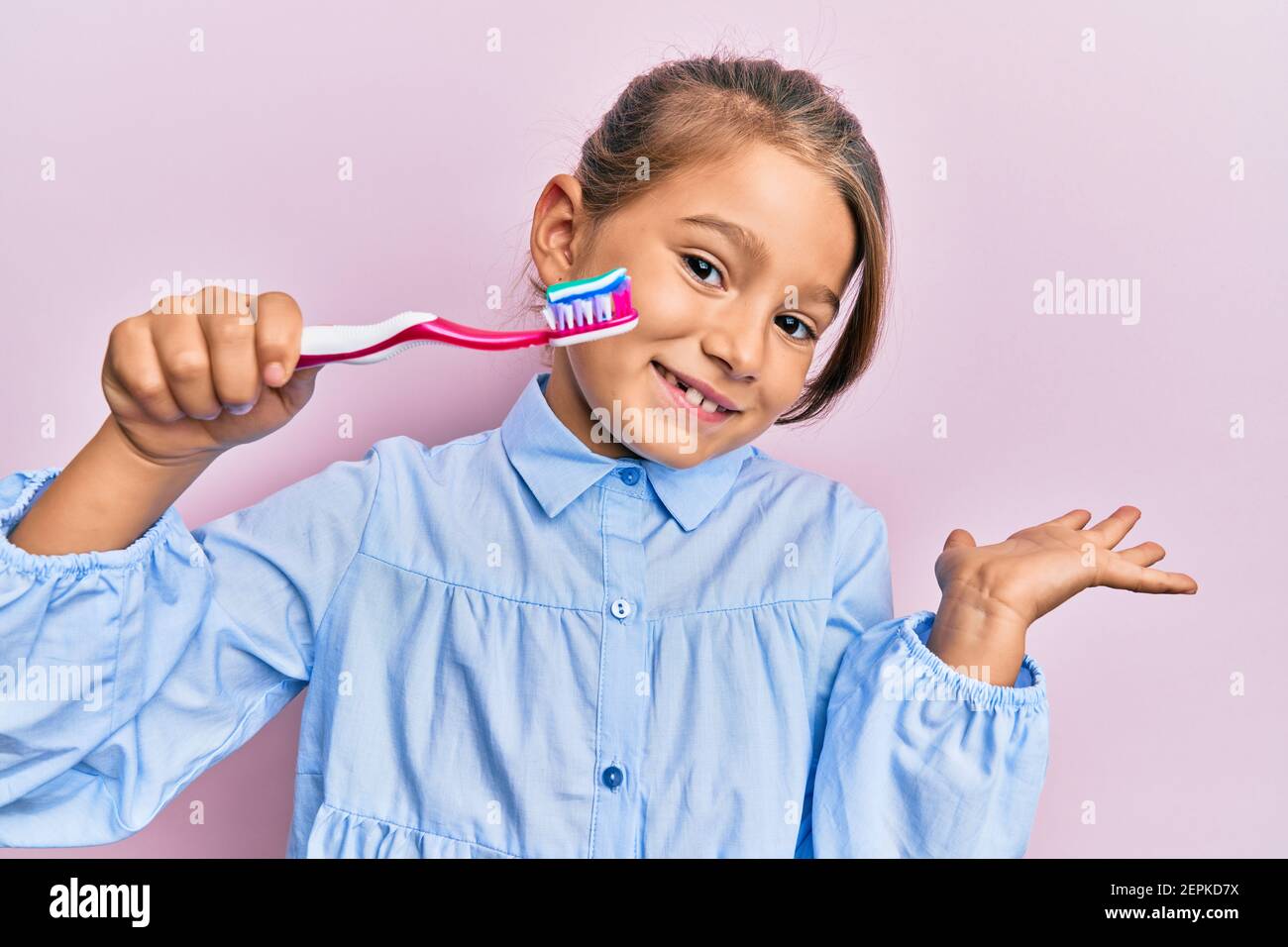 Little beautiful girl holding toothbrush with toothpaste celebrating ...