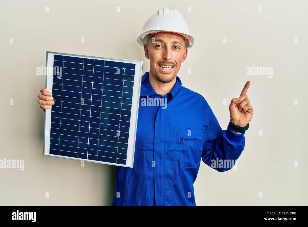 Bald engineer man with beard holding photovoltaic solar panel smiling ...
