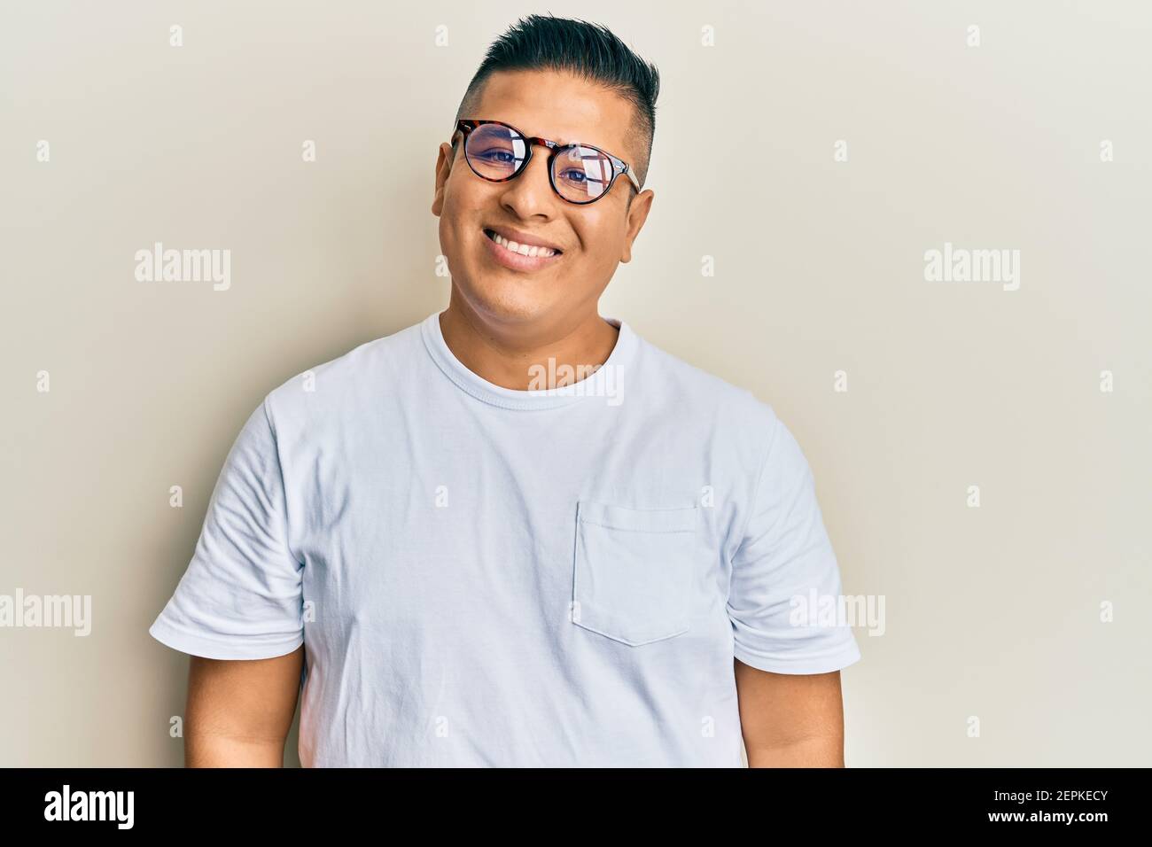 Young latin man wearing casual clothes and glasses with a happy and ...
