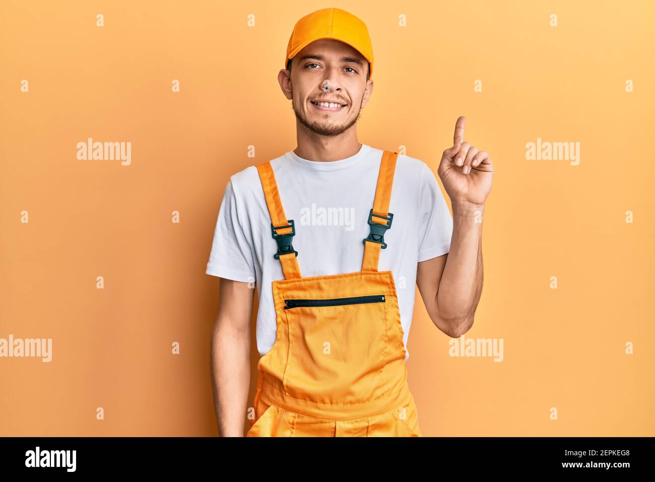 Hispanic young man wearing handyman uniform with a big smile on face ...