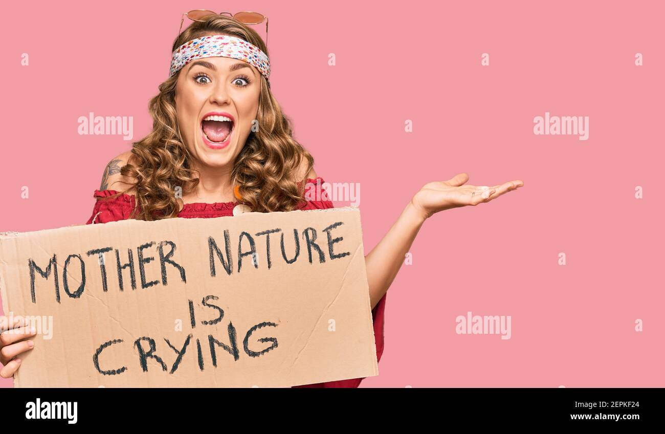 Young blonde girl wearing hippie style holding mother nature is crying ...
