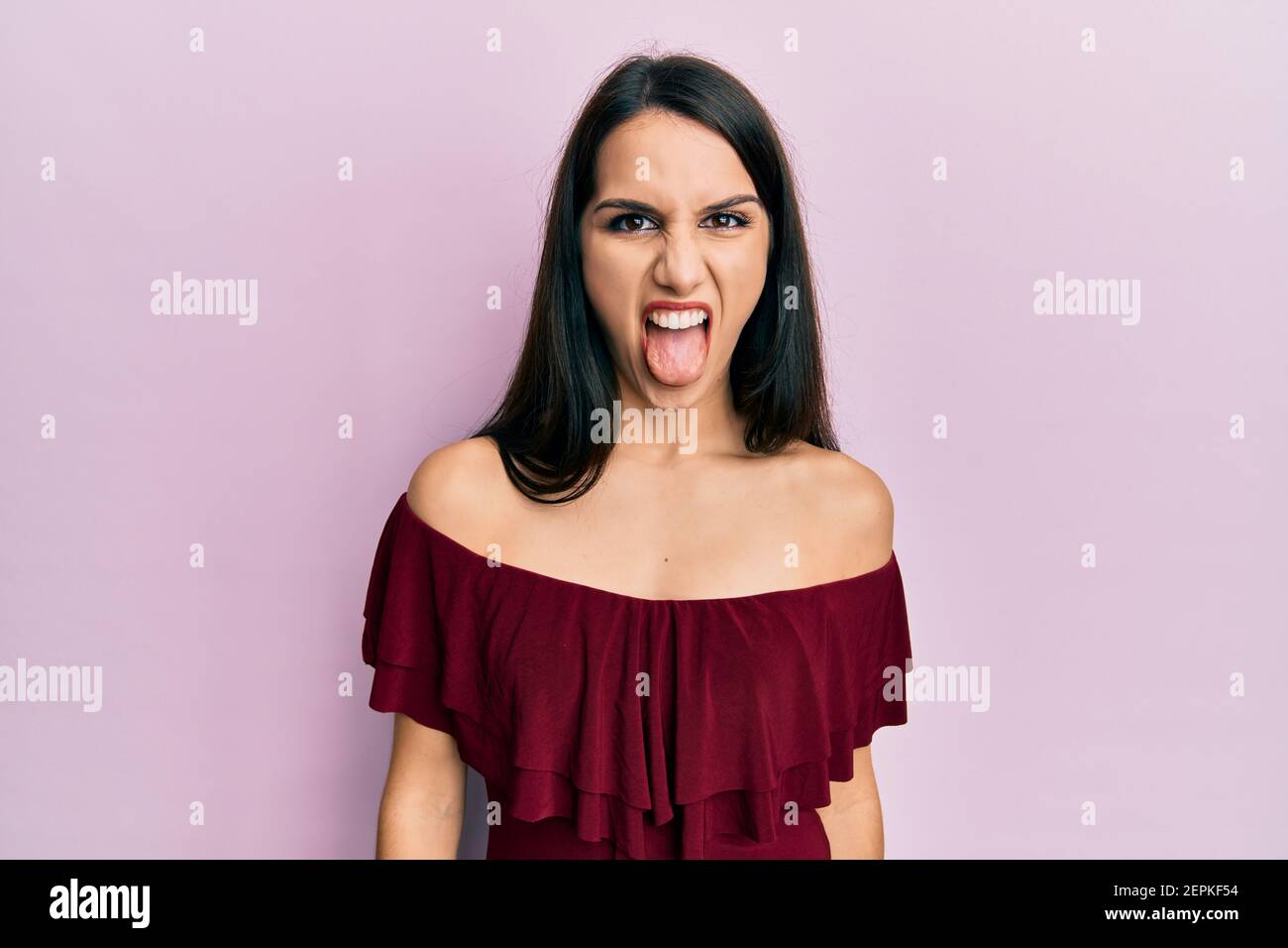 Young hispanic woman wearing casual clothes sticking tongue out happy ...